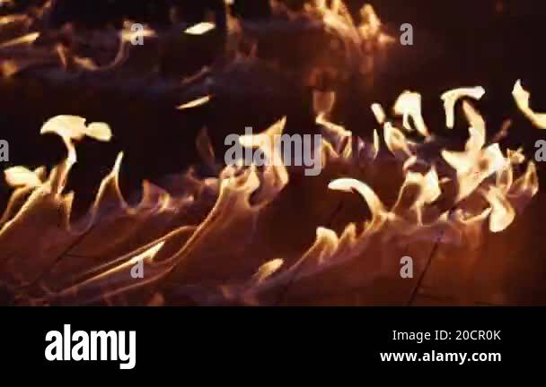 Close up flames move across a concert floor fire floor exterior night ...