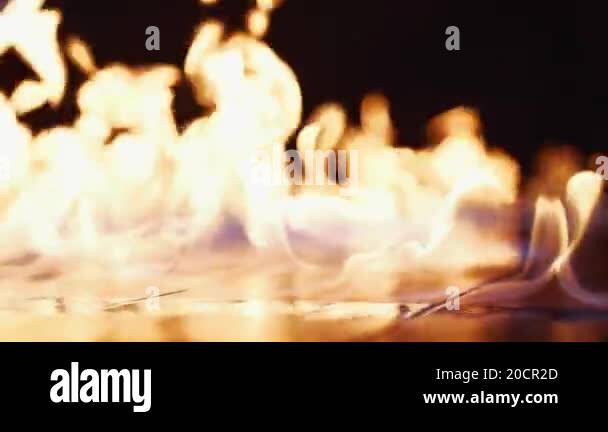 Close up flames move across a concert floor fire floor exterior night ...