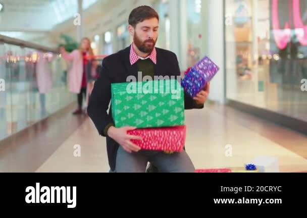 Sad attractive man trying to keep the boxes constantly falling to the ...