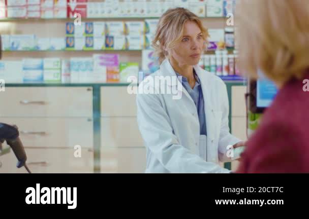 Close up woman pharmacist serving a customer in a drugstore ...