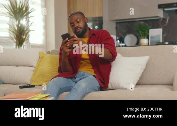 Attractive young african american man use phone puts the phone on the ...