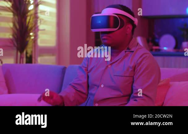 Close up mixed race young man wearing virtual reality headset sitting ...