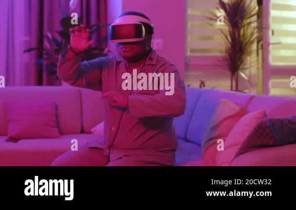 Close up mixed race young man wearing virtual reality headset sitting ...