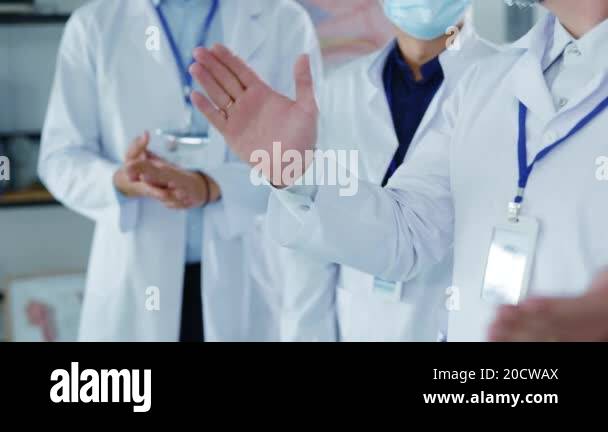 Close-up of medical diverse workers employee staff clapping hands ...