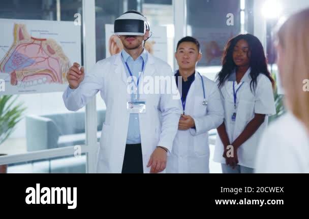 Caucasian young doctor presenting his artwork presentation 3D technology wearing VR headset ...