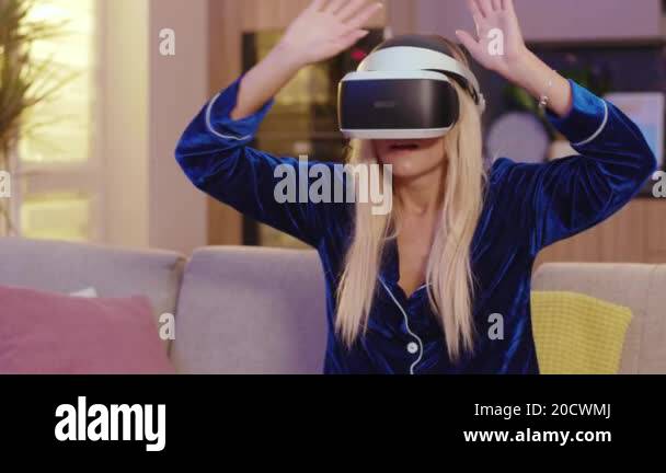 Happy woman at home experiencing virtual reality 3D games simulation ...