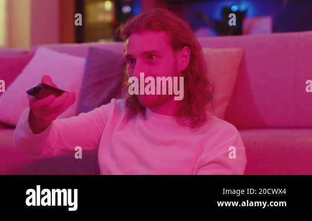 Happy cheerful man switching TV channels watching favorite show comedy ...