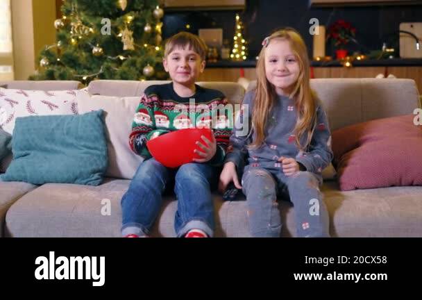 Adorable two caucasian young little children eating popcorn watching ...