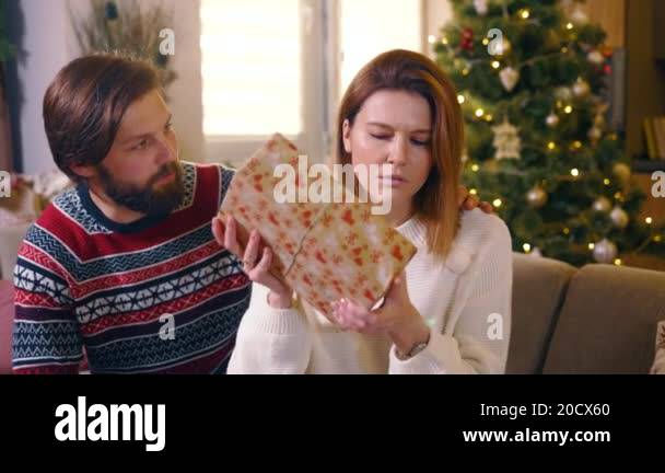 Caucasian romantic couple exchange gifts near christmas tree. Young ...