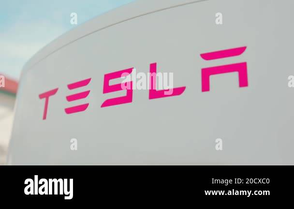 Close-up horizontal footage of Tesla logo. White and pink colors. EV ...