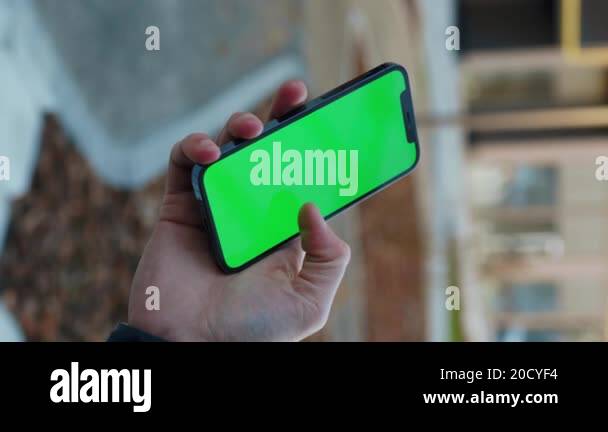 NEW YORK - December, 19 2020: Close up vertical shot man hand using touch phone with vertical ...