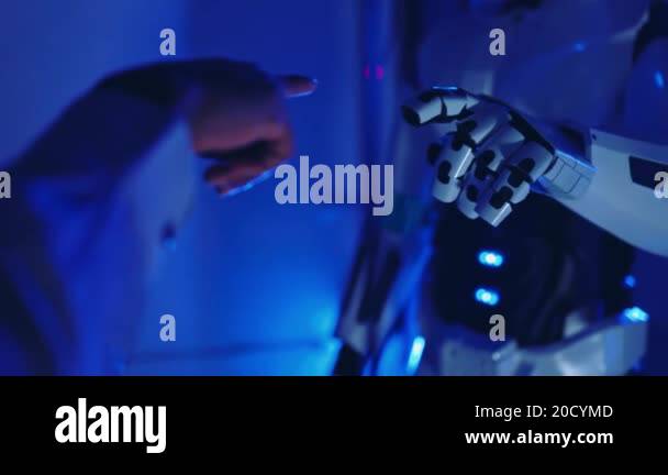 Hand of a businessman touch finger with a cybernetic robot. Human interaction with artificial ...