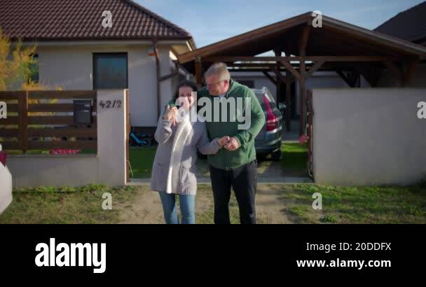 Couple standing closely together, arms entwined as they share a tender ...