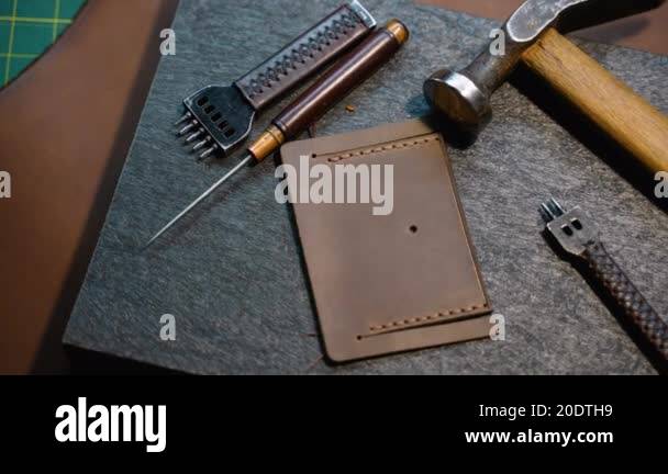 A detailed shot of leatherworking tools and a wallet in progress ...