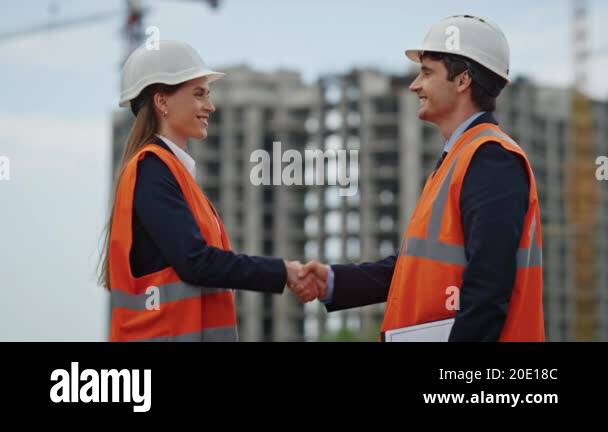 Smiling architects handshake at construction site. Successful ...