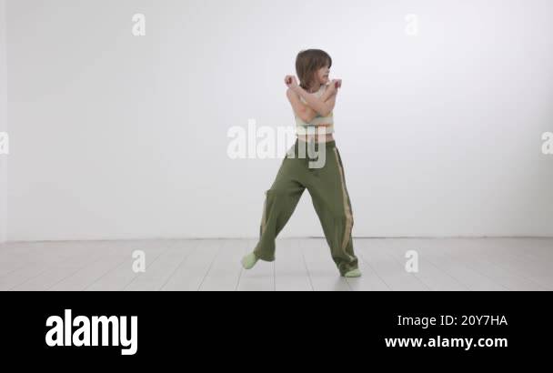 child demonstrates dance moves in a spacious studio during an afternoon ...
