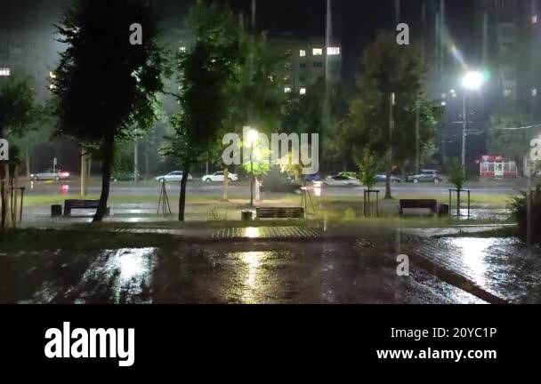 Heavy rain falling in the city on summer night. Heavy rain, road with ...