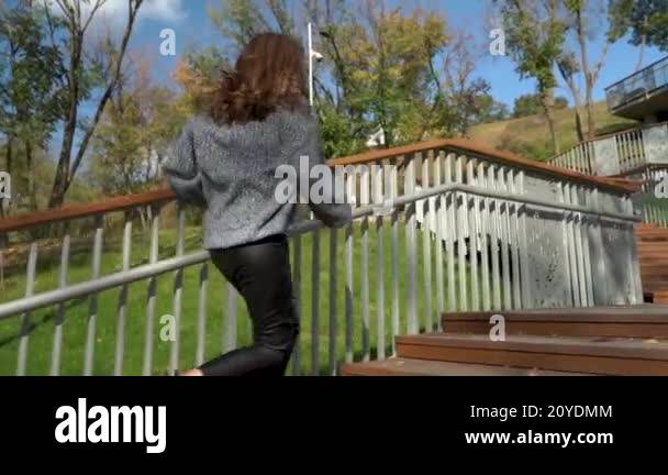 This video shows a woman moving through scenic outdoor stairs, from ...