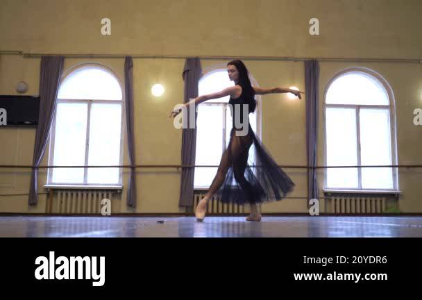 Graceful ballerina dancing elements of classical ballet in the dance studio. Talented caucasian ...