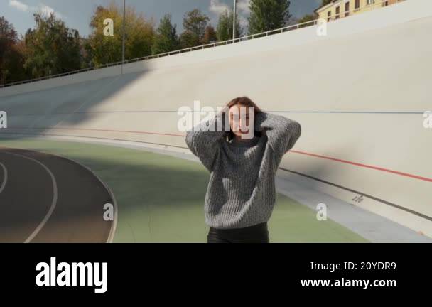 A young woman enjoys a brisk run on a beautiful and scenic sports track ...