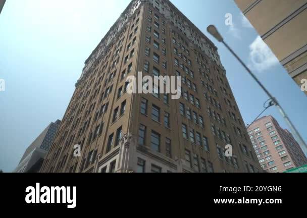 A tall brick building with intricate architectural details rises into ...