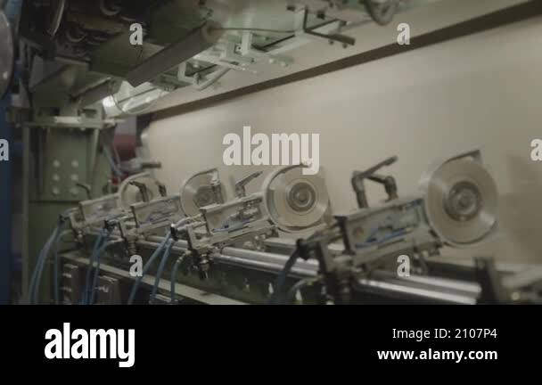 Factory workshop with machines for winding cardboard into rolls ...