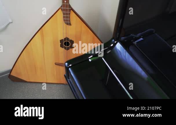 Large balalaika neatly placed on floor near piano elegantly designed ...