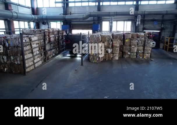 Truck reverses into warehouse with bales of waste paper. Vehicle ...