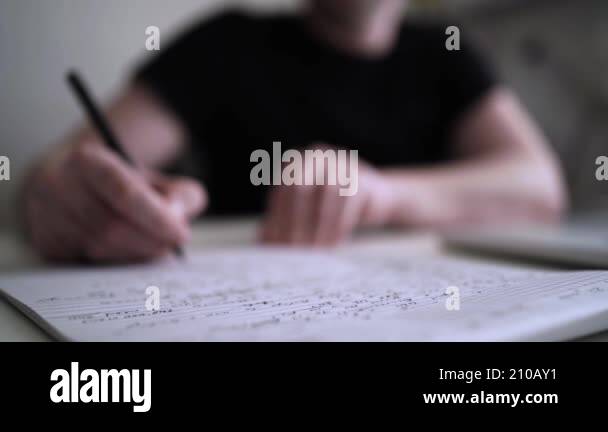 man journaling his thoughts into notebook, because he has some sort of ...
