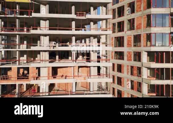 Workers are engaged in the construction of a multi-story building ...