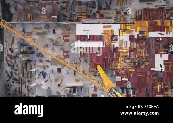 Construction workers are busy on a large site, stacking and organizing ...