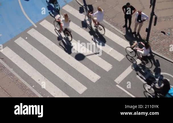 Cyclists and pedestrians crossing crosswalk in Copenhagen on sunny day ...