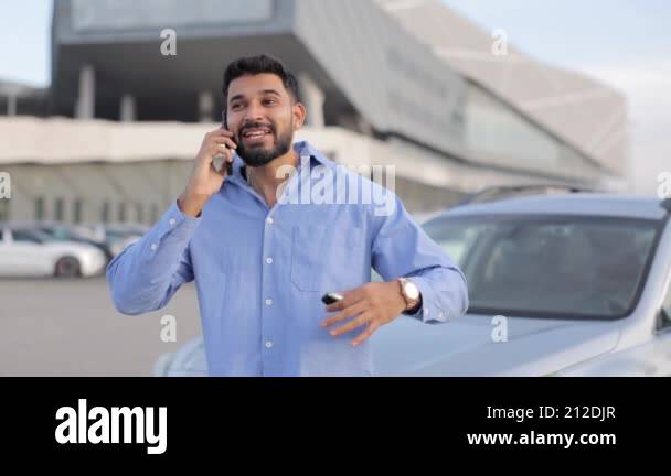 Happy Caucasian man talking on phone, while locking car with automatic ...