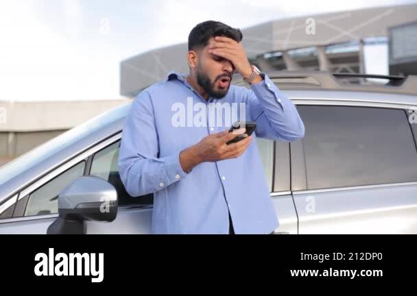 Perplexed attractive guy rubbing forehead, while looking at phone ...