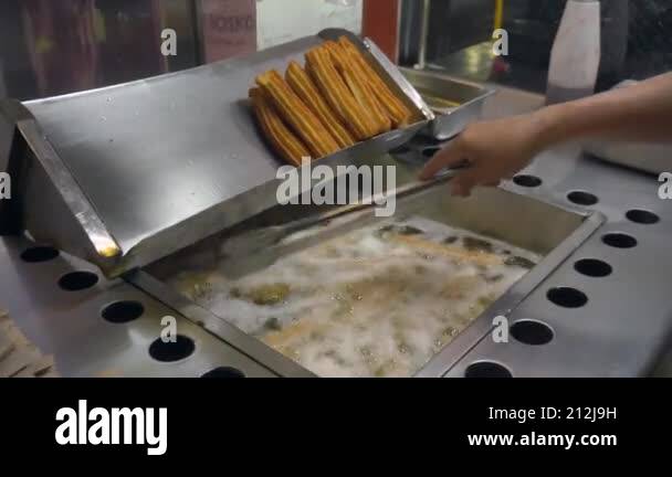 Frying Churros in deep oil in Churreria. Traditional Mexican Dough ...