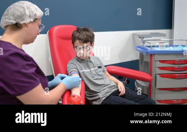 A nurse takes blood from a child using butterfly needle. Close up view ...