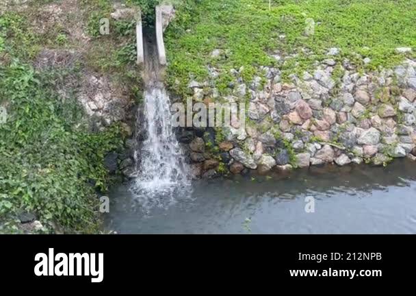 Pipe overflowing natural resource water into canal, stock footage Stock ...