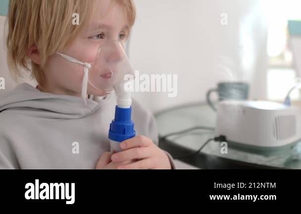 Preteen boy inhalation therapy by the mask of inhaler. Close up video ...
