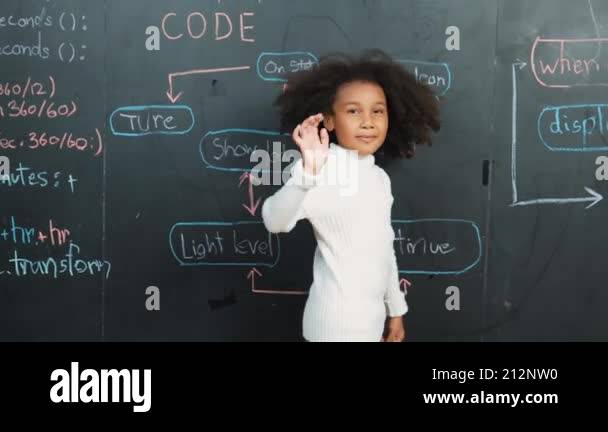 African girl smiling and waving at camera while standing at board with ...