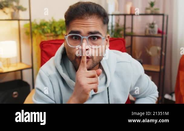 Shh be quiet please. Indian young man presses index finger to lips ...