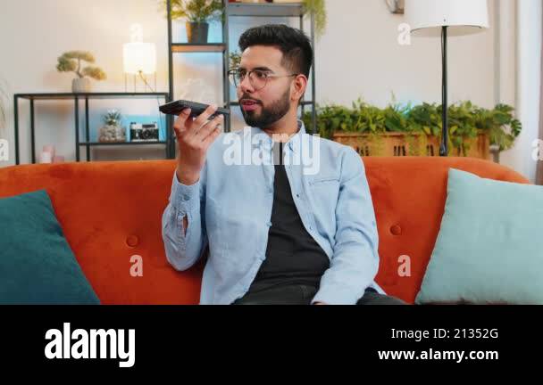 Cheerful Indian man enjoying mobile loudspeaker talking gossip, rumors ...