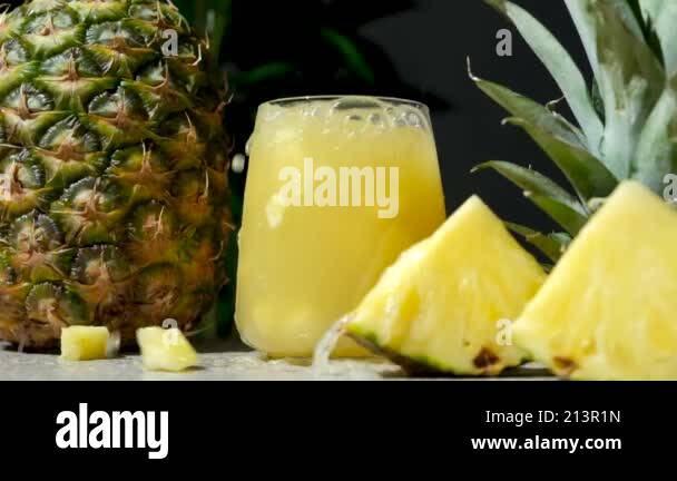 Pineapple juice splash, slow motion. Pieces of fresh pineapple fall ...