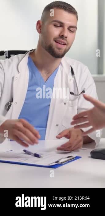 Vertical Screen: Confident doctor in a professional setting interacts ...