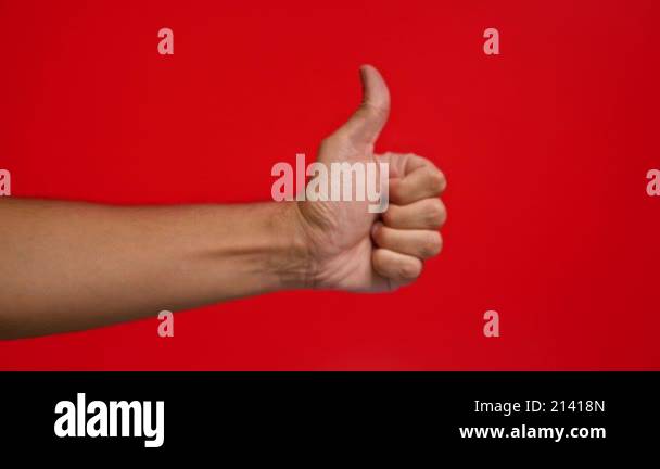 Man showing positive thumbs-up gesture with his right hand in front of ...