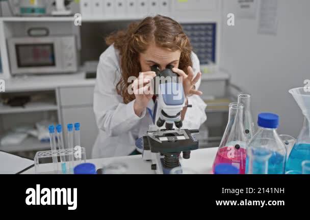Smiling young woman scientist masterfully juggling microscope analysis ...