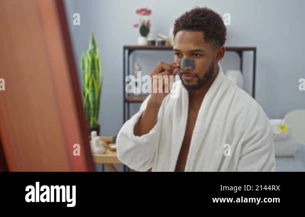 Young man applying and removing a nose strip in a serene spa setting ...