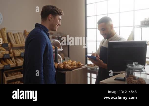 Men working in a bakery, one showing something on tablet to another ...