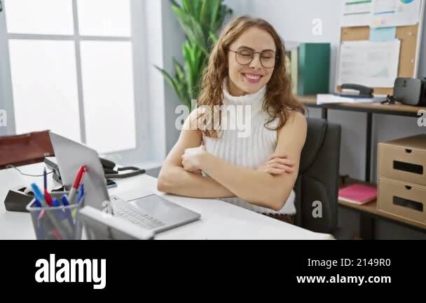 Beautiful, young woman oozing confidence in her office, smiling, happy ...