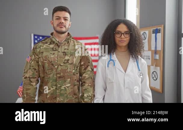 A confident female doctor and a male soldier stand with crossed arms in ...