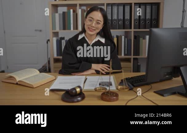 Woman judge in office smiling with law books and gavel on desk filed ...